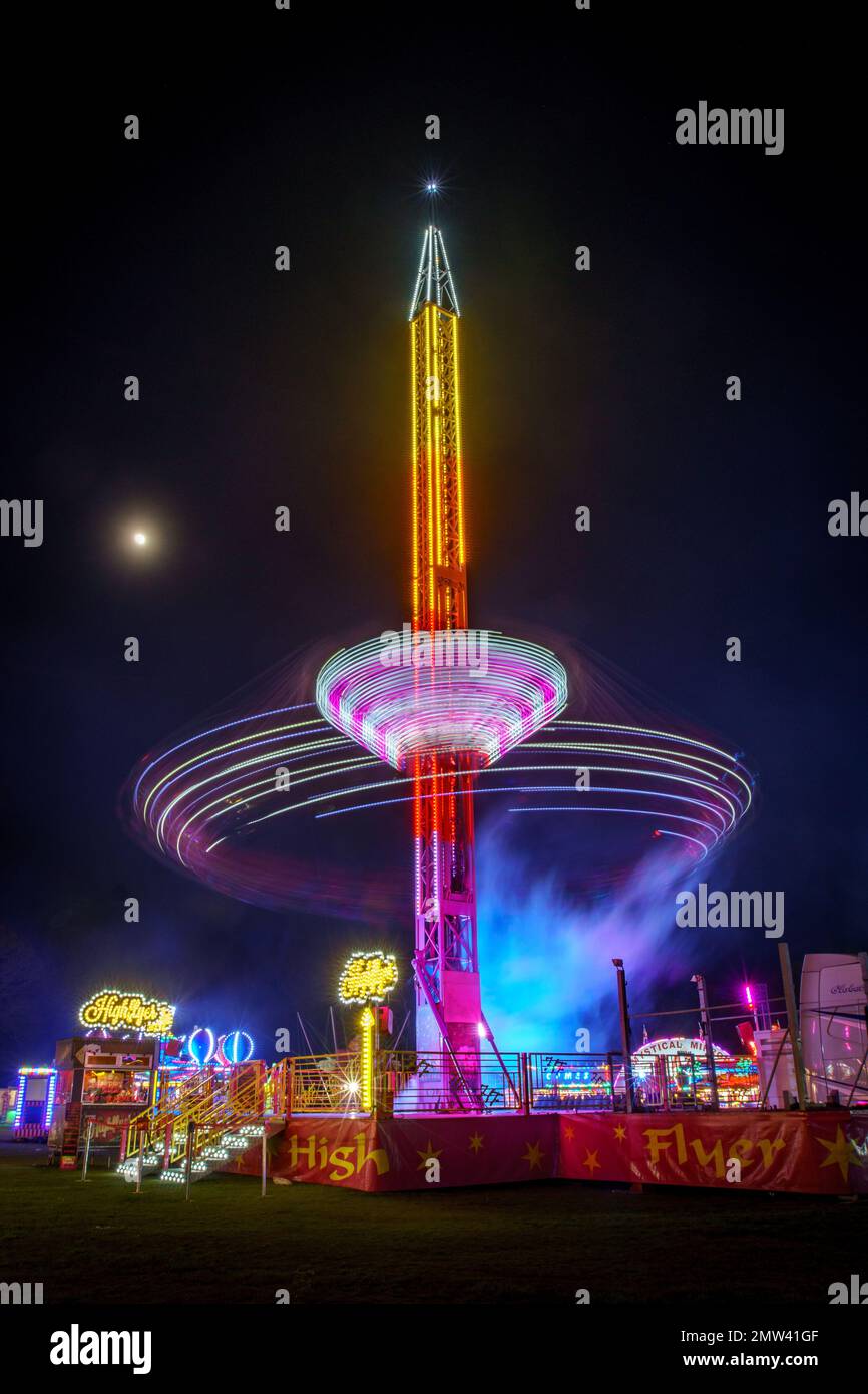 A Fun fair ride at night, spinning long exposure with smoke at the base ...