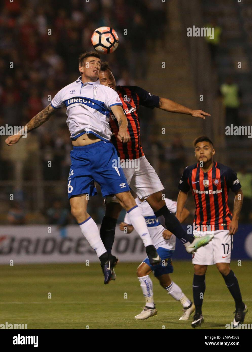 Cesar Fuentes, left, of Chile's Universidad Catolica jumps for a ball ...