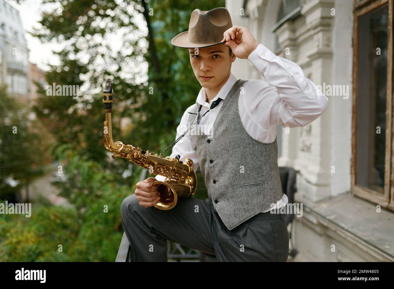 Portrait of young musician holding saxophone musical instrument Stock ...