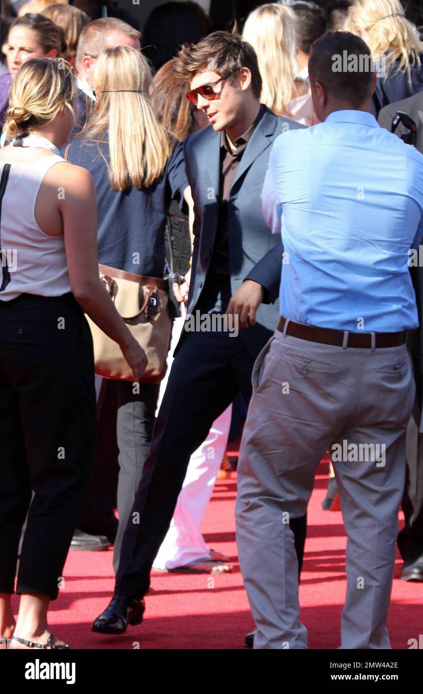 Actor Zac Efron hugs a female friend before he heads down the red ...