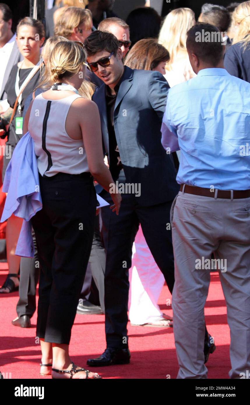 Actor Zac Efron hugs a female friend before he heads down the red ...