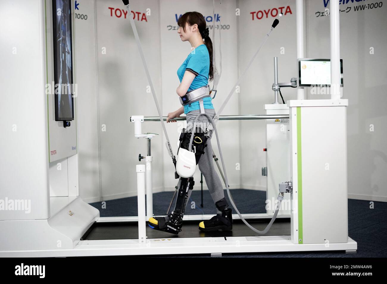 A model demonstrates the Welwalk WW-1000, a wearable robotic leg brace ...
