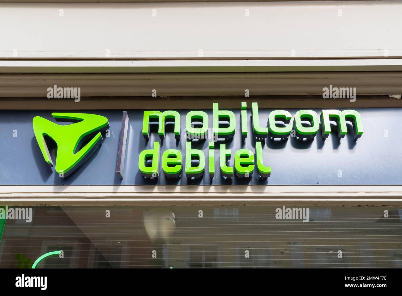The green logo of the Mobilcom Debitel in Spandau on a house facade ...
