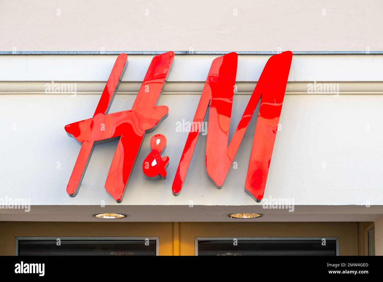 The logo of the H&M clothing store in Potsdam on a house wall above the ...