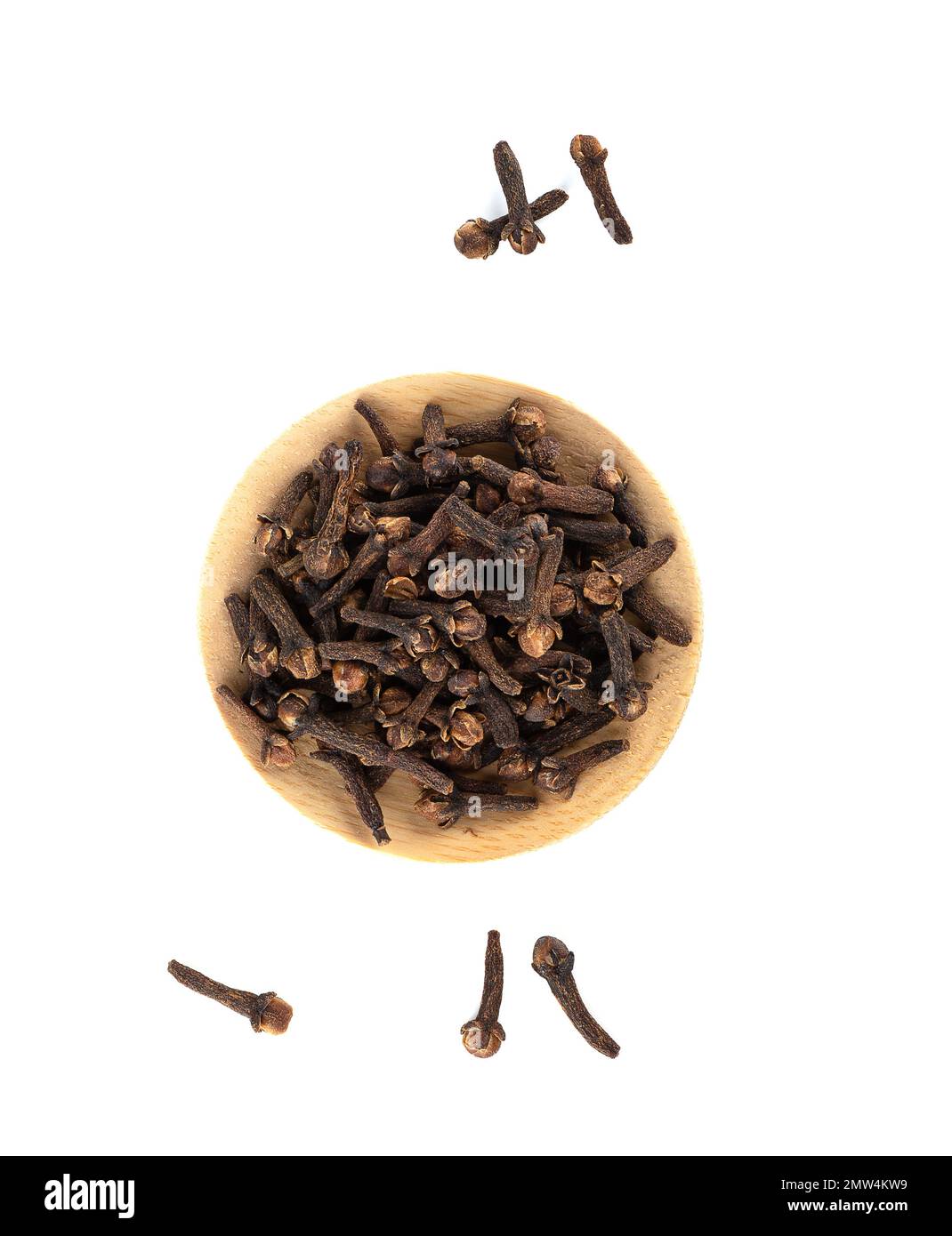 Top view of spice cloves on a wooden plate and on a white background ...