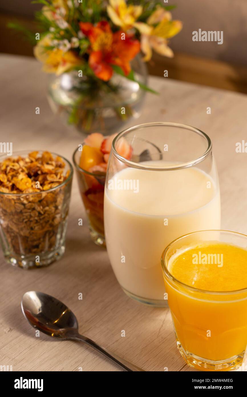 A vertical shot of a Healthy breakfast consisting of fruits, milk, and ...