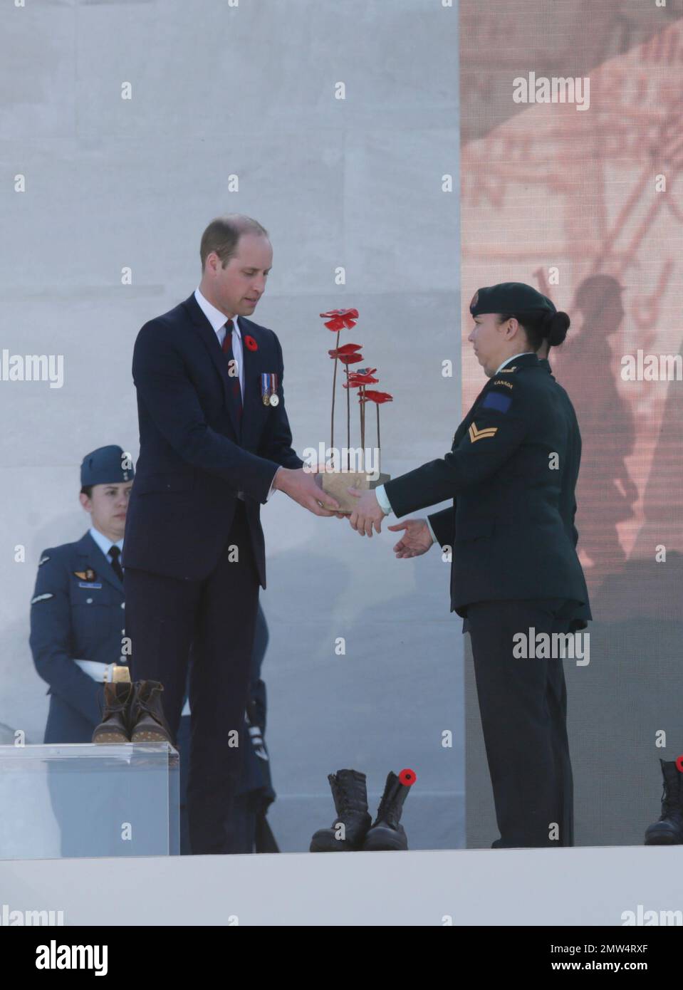 The Duke of Cambridge prepare to place poppies next to a pair of boots ...