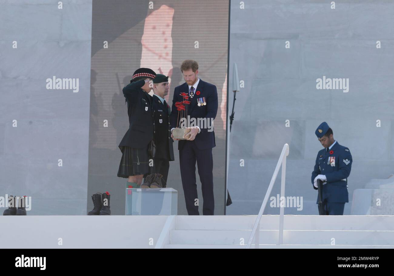 Britain's Prince Harry prepares to place poppies next to a pair of ...