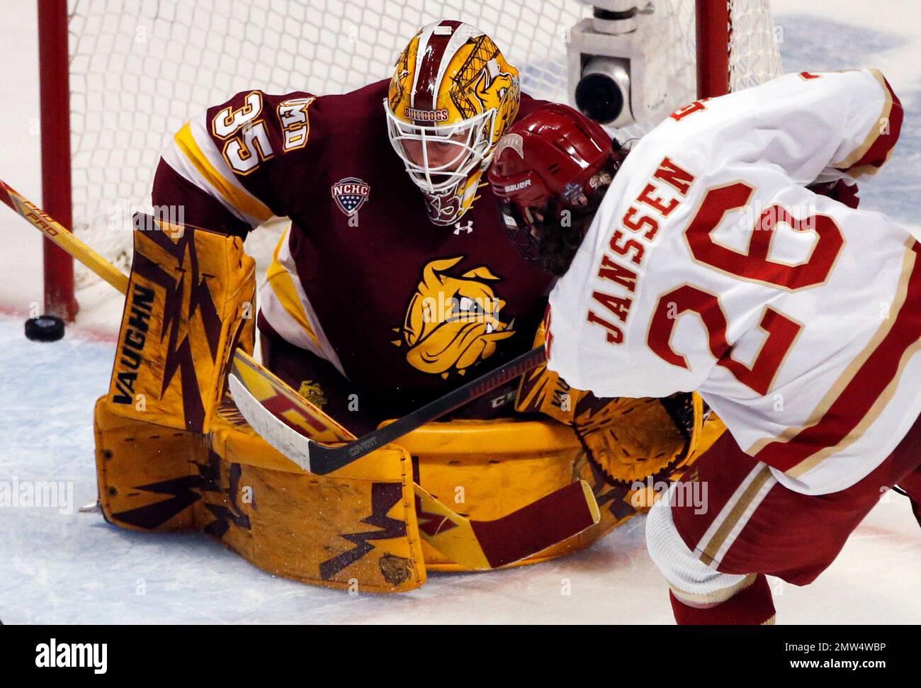 Minnesota-Duluth goalie Hunter Miska, left, blocks a shot by Denver ...