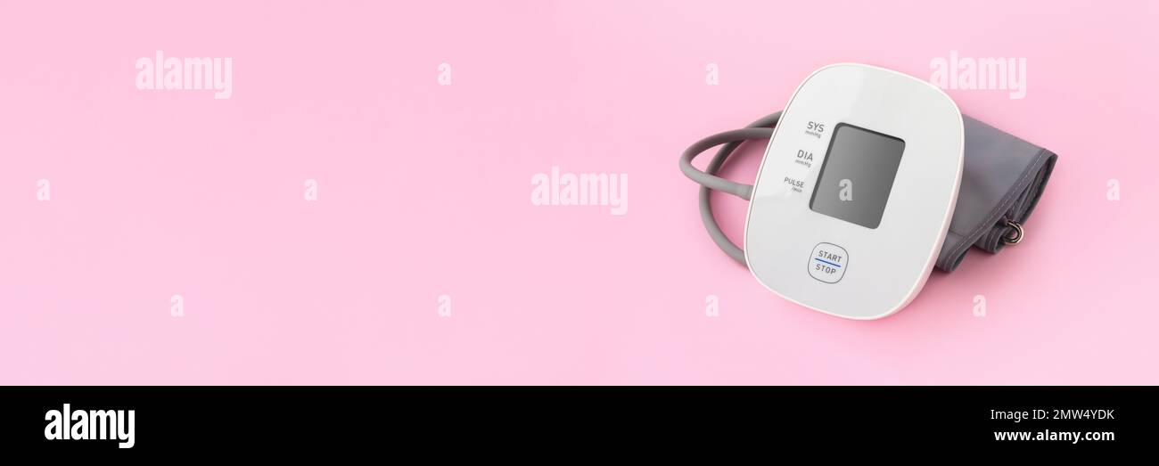 Automatic blood pressure monitor on pink background banner. Medical ...