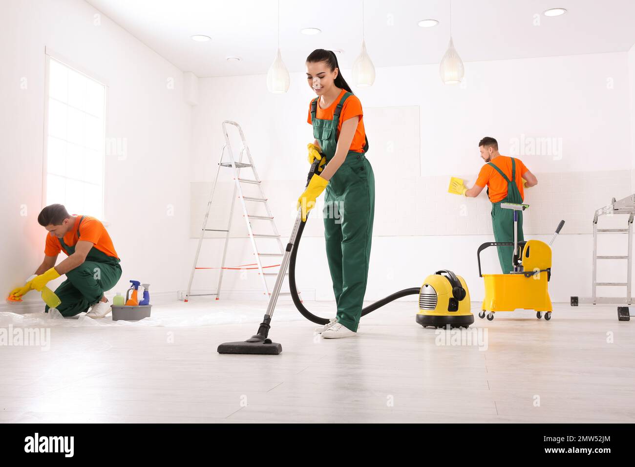 Team of professional janitors cleaning room after renovation Stock ...