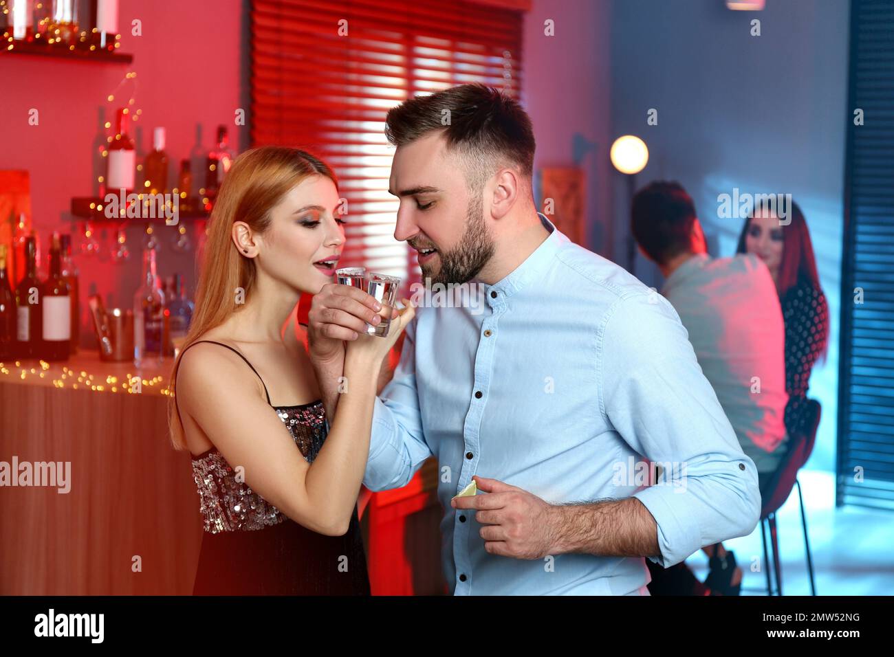 Young couple drinking Mexican Tequila shots in bar Stock Photo - Alamy