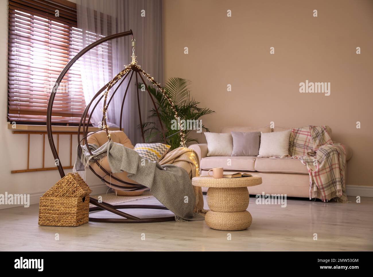 Cozy hanging chair with fairy lights in modern living room. Interior ...