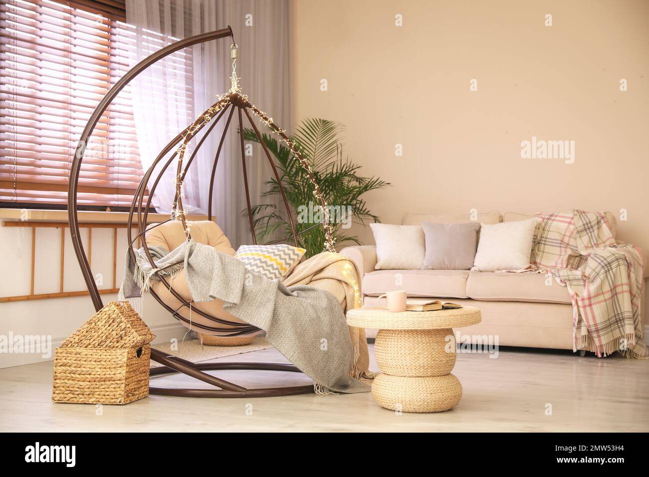 Cozy hanging chair with fairy lights in modern living room. Interior ...
