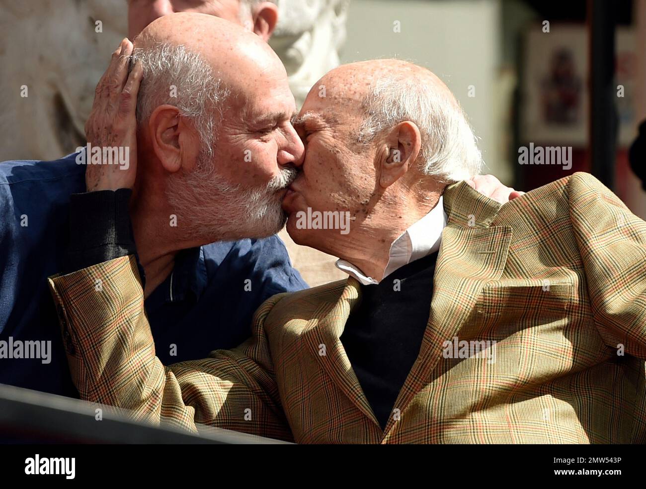Rob Reiner, left, and his father Carl Reiner kiss during a hand and ...