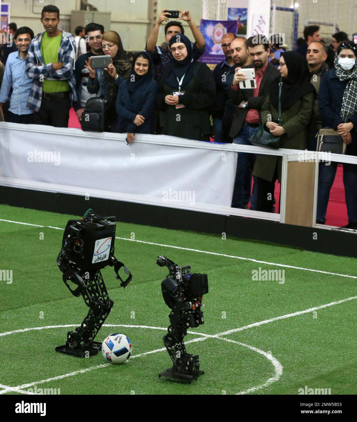 Visitors follow a soccer match of humanoid robots during the 12th ...