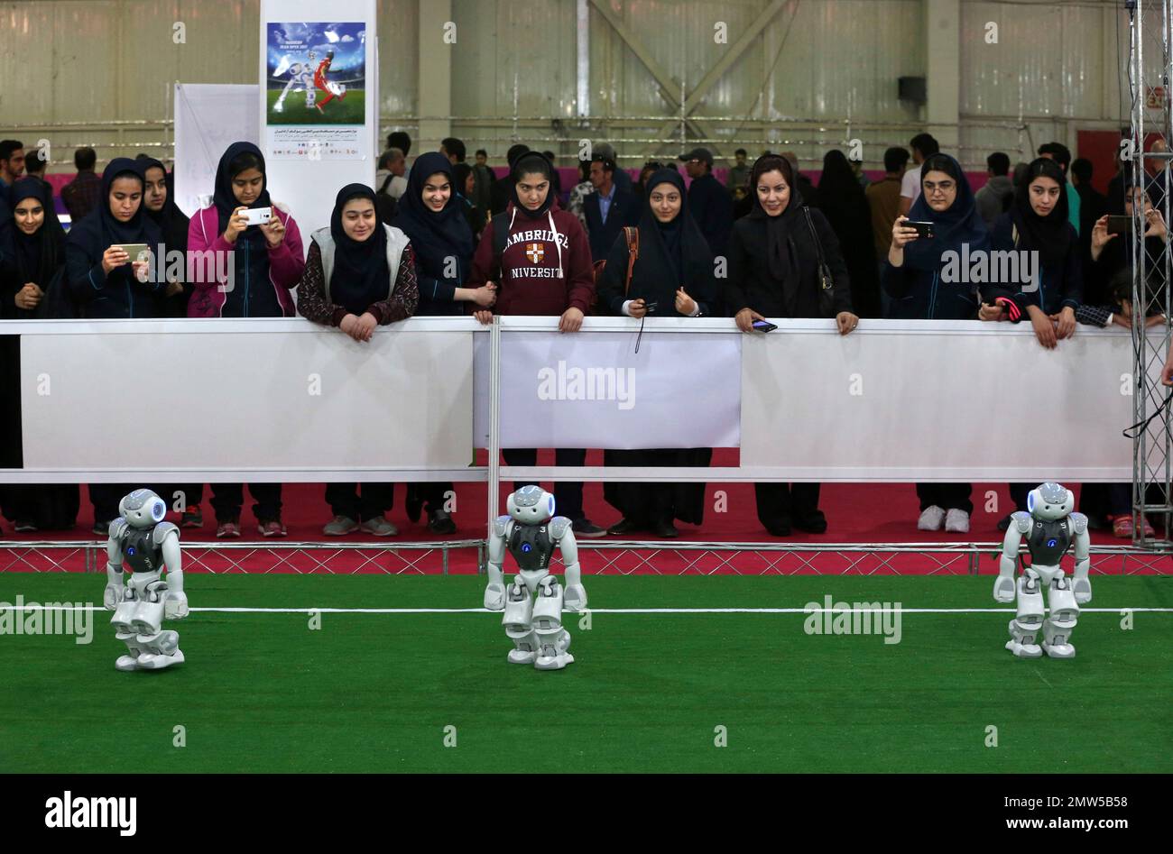 Iranian women follow the soccer matches of humanoid robots during the ...