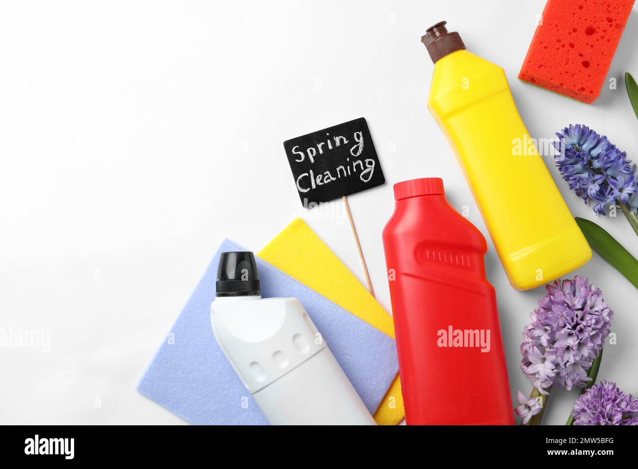 Composition with Spring Cleaning sign, flowers and detergents on white ...