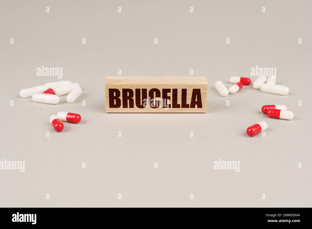 Medical concept. On a gray surface are tablets, capsules and a wooden ...