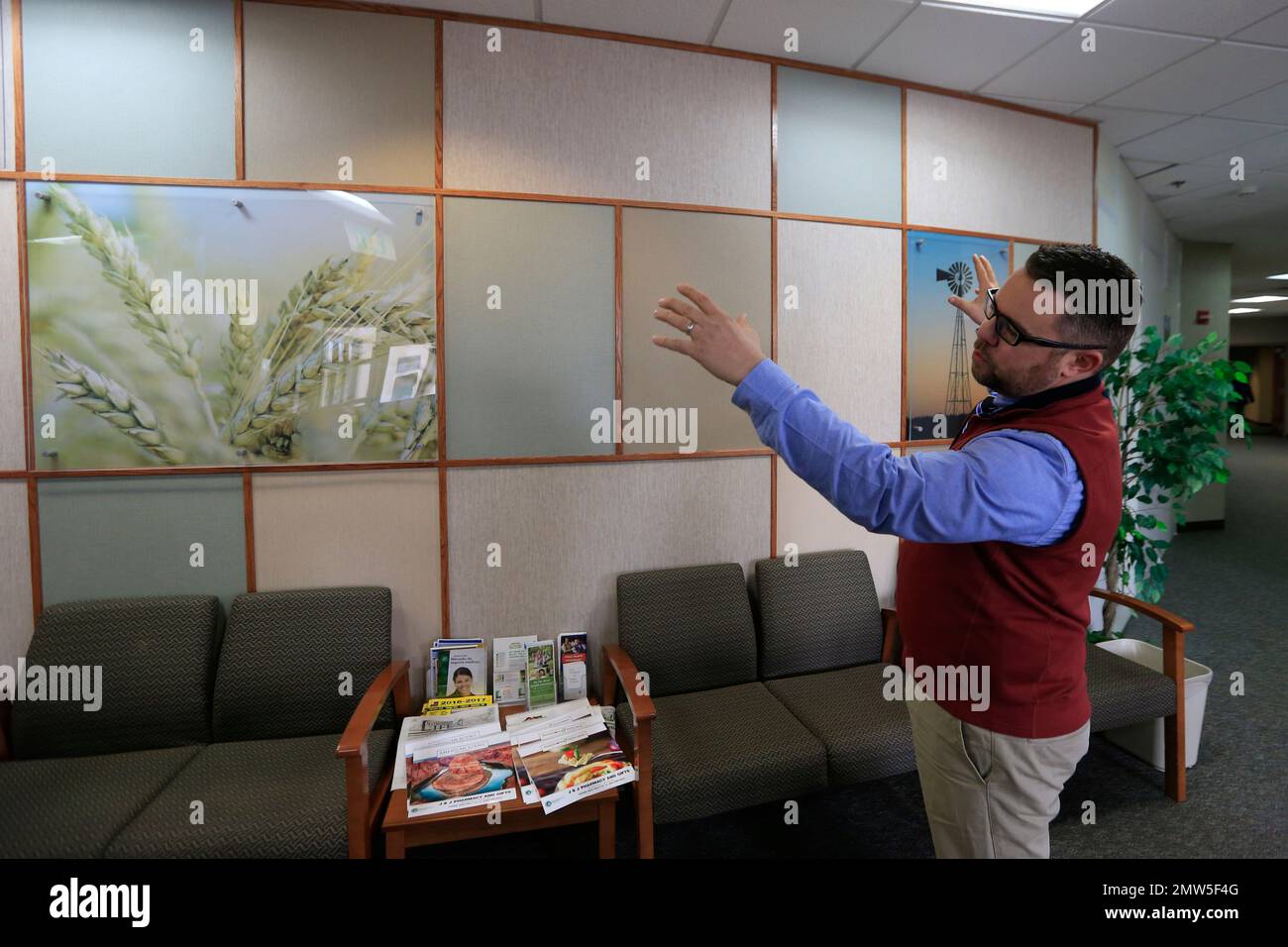 Benjamin Anderson, CEO of Kearny County Hospital, points to photos ...