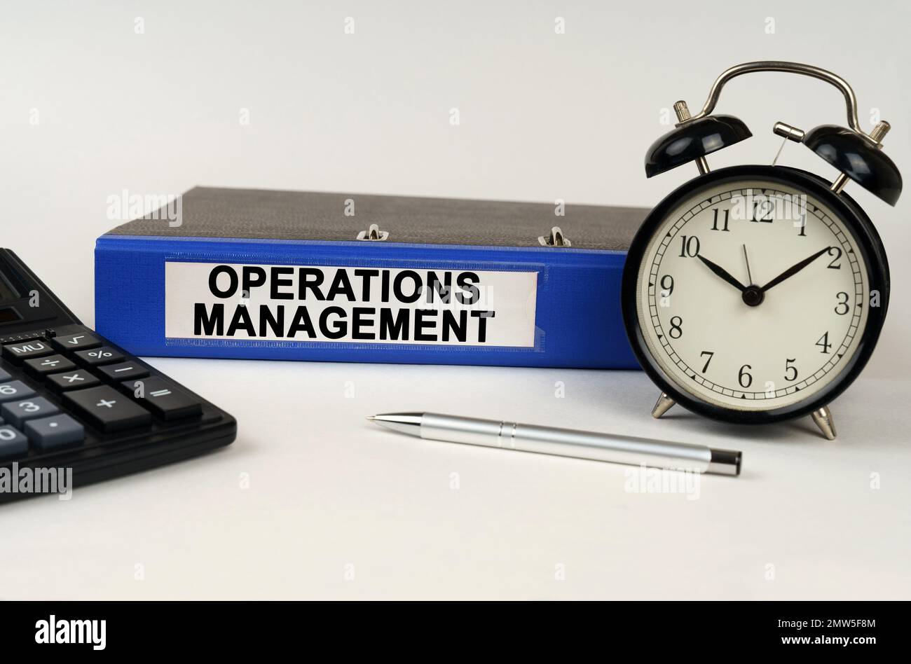 Business concept. On a white surface, an alarm clock calculator and a ...