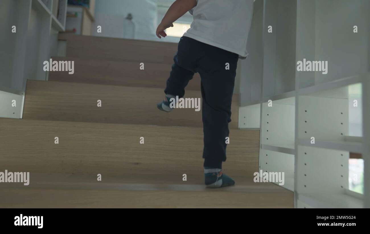 Child going up the staircases at home. One little boy climbing stairs ...