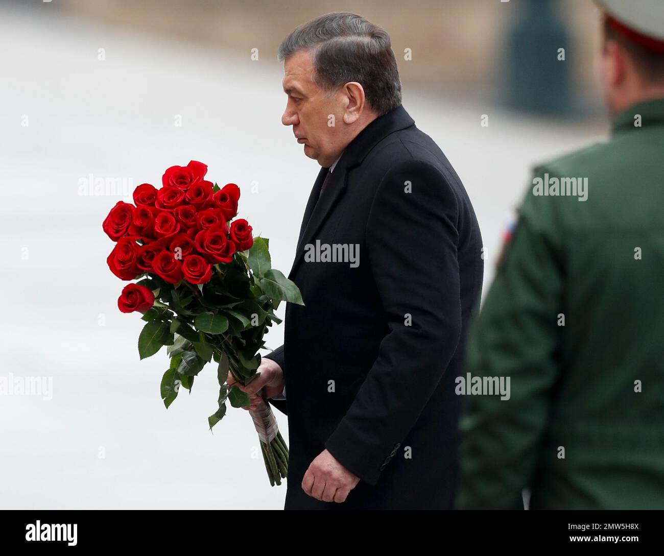 Uzbek President Shavkat Mirziyoyev walks with flowers to put them at the memorial stone with the ...