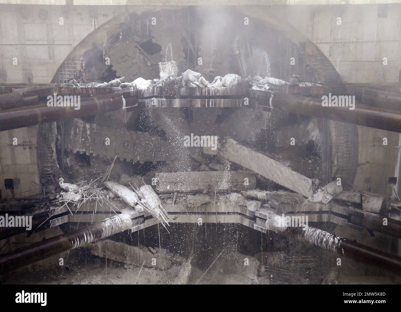 A massive tunneling machine breaks through a five-foot wide concrete ...