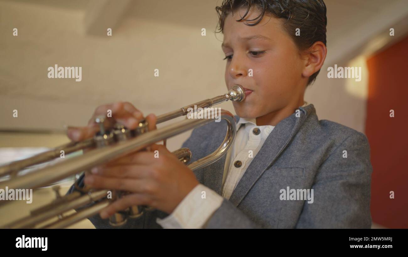 Young boy playing trumpet indoors. Teen child practicing musical instrument Stock Photo - Alamy