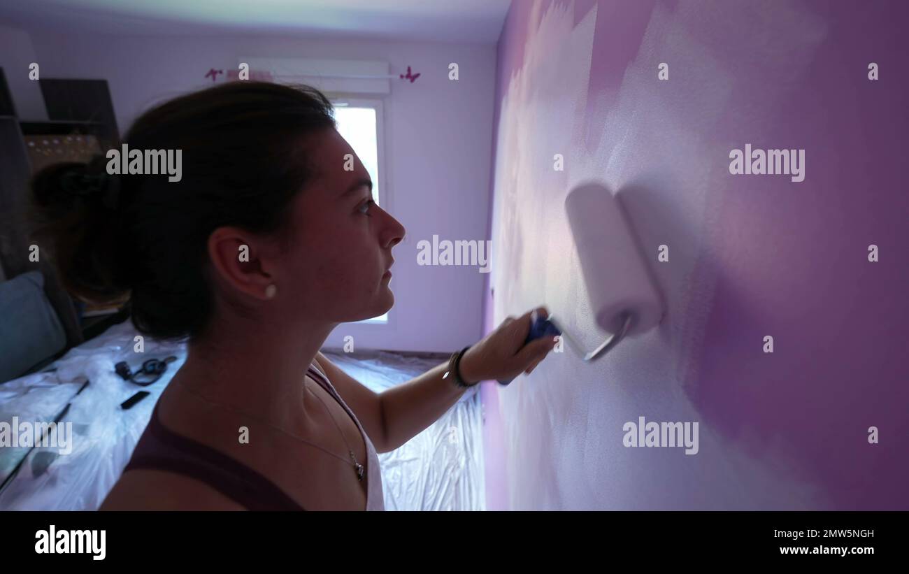Person painting wall. Woman painter moving paint roller. DIY house ...