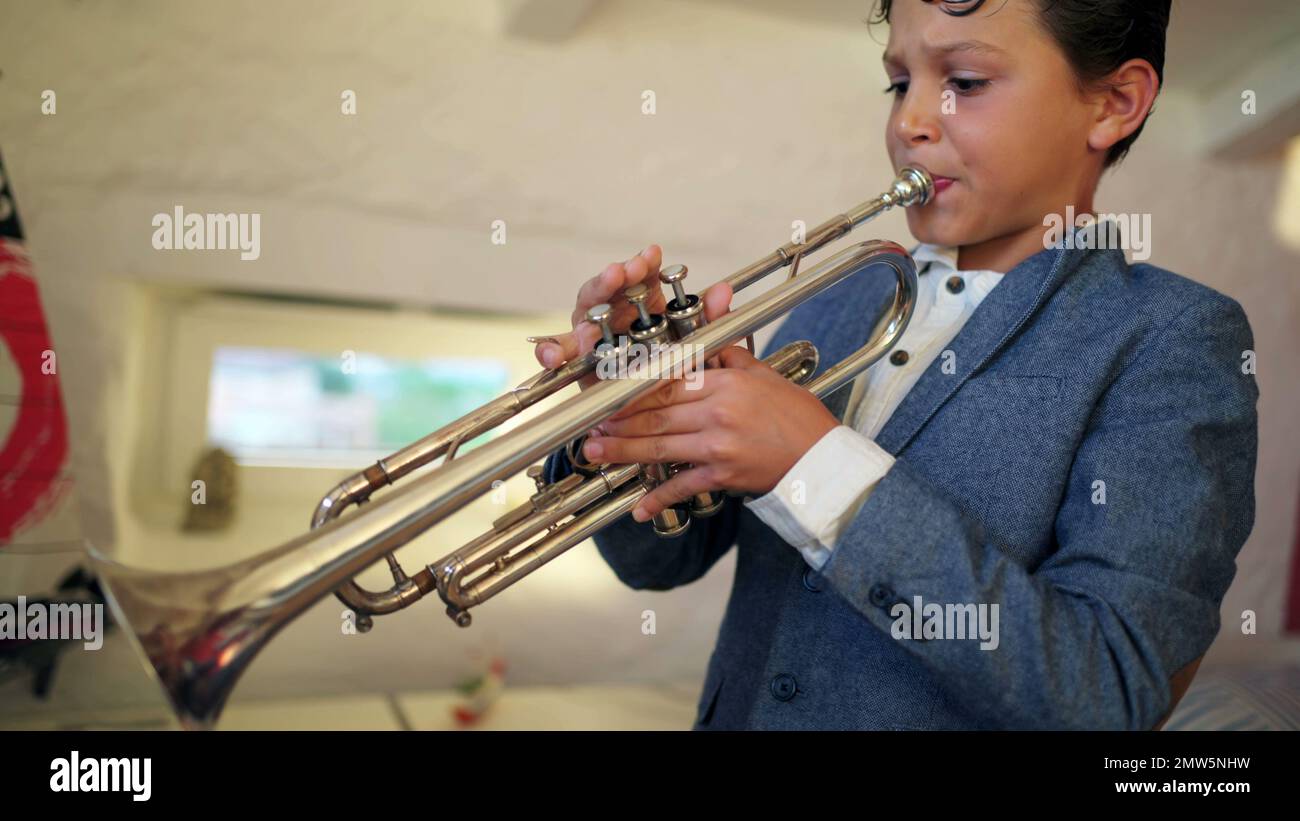 Young boy playing trumpet indoors. Teen child practicing musical ...