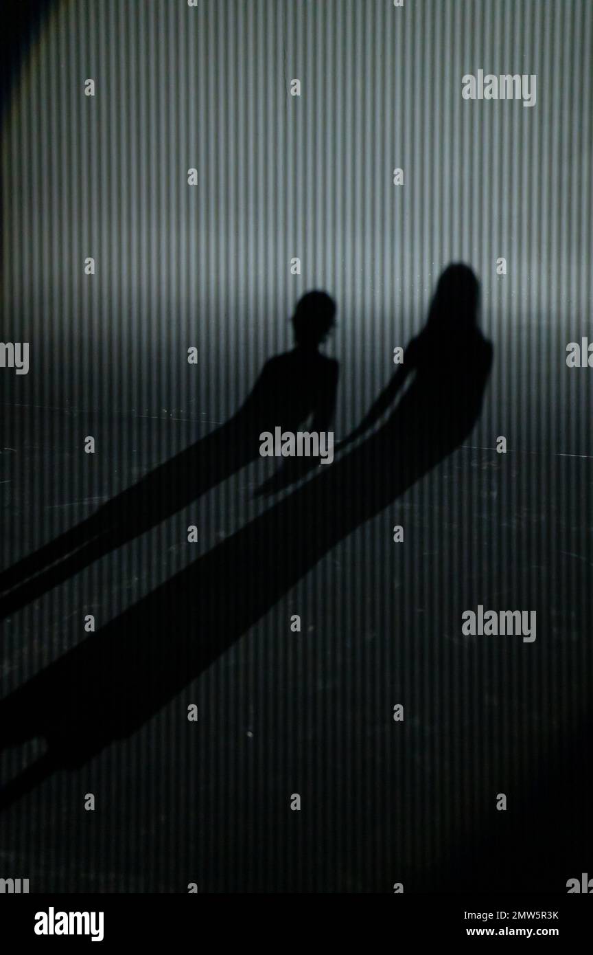 kid's shadows on wall. shadow of two children, boy and girl on striped ...