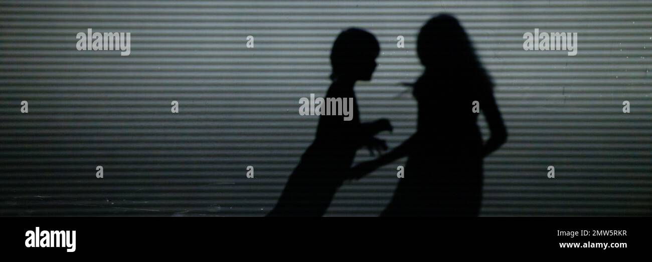 kid's shadows on wall. shadow of two children, boy and girl on striped ...