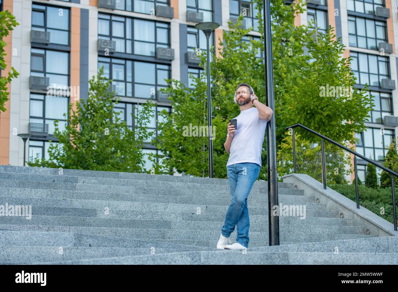 man in music headphones in the street, full length. man in music ...