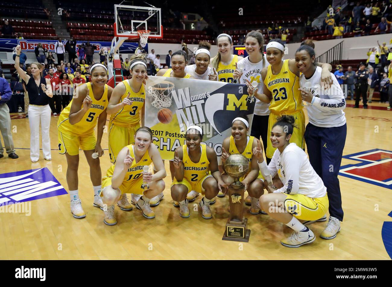 Michigan players pose with the winner's trophy after the WNIT ...