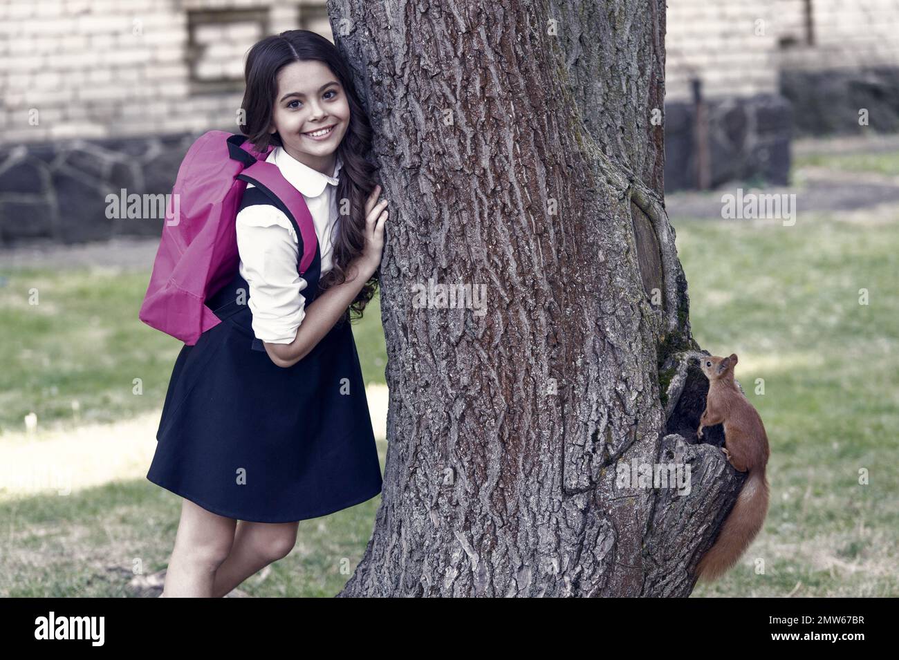 Happy small kid in uniform with school backpack research squirrel ...