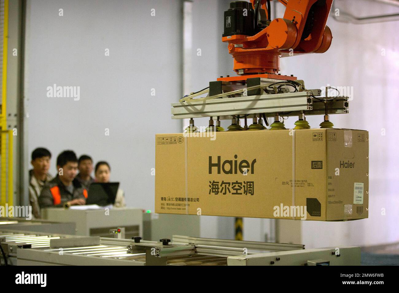 In this Friday, Feb. 24, 2017 photo, factory workers watch as a machine ...