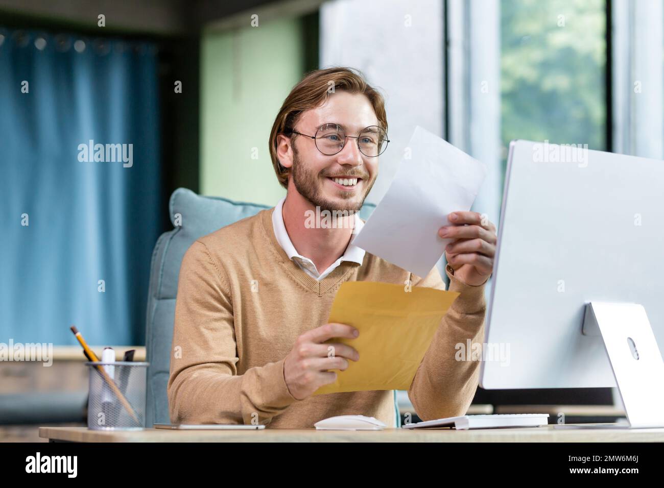 Young successful businessman in casual interior of office, blond man ...