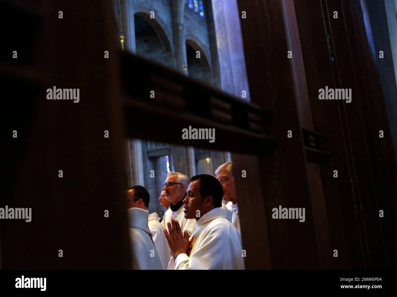 Catholic clergy pray during a funeral Mass for Cardinal William Keeler ...