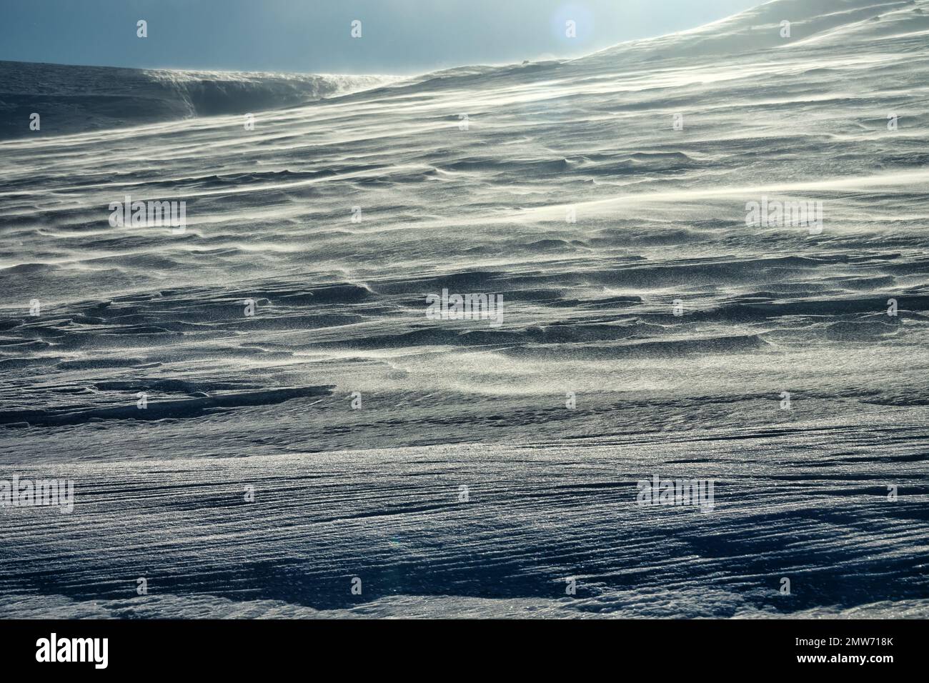 Strong wind on the snowy frosty Northern slope of the mountain ...