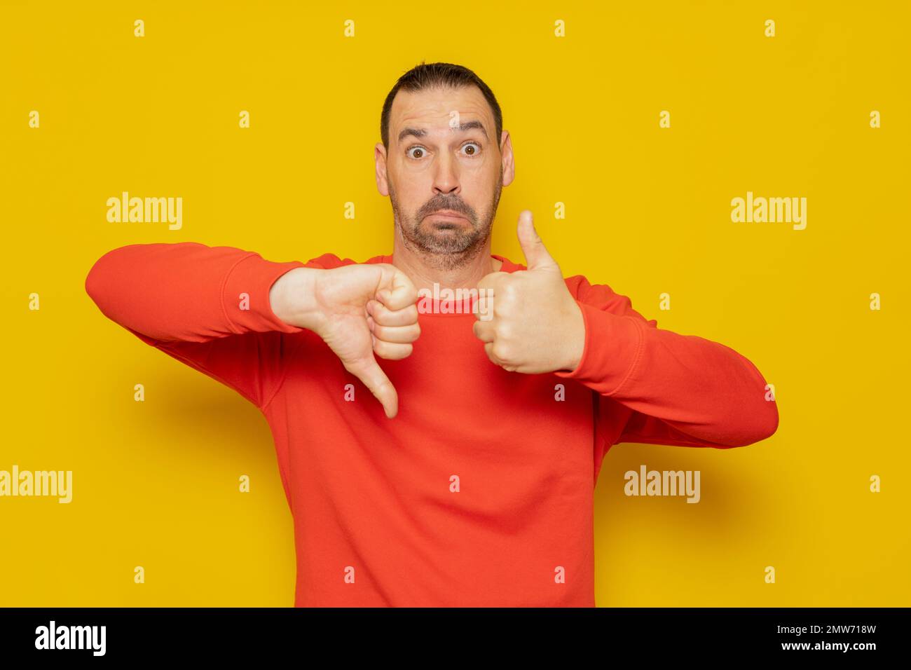 Hispanic man with beard making good and bad signs. Person undecided ...