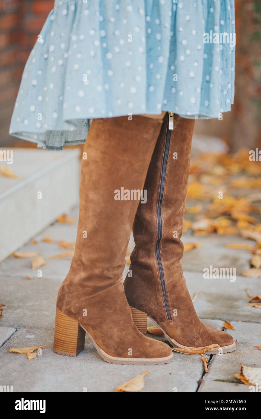 A vertical shot of a model wearing a light blue polka dot skirt and ...