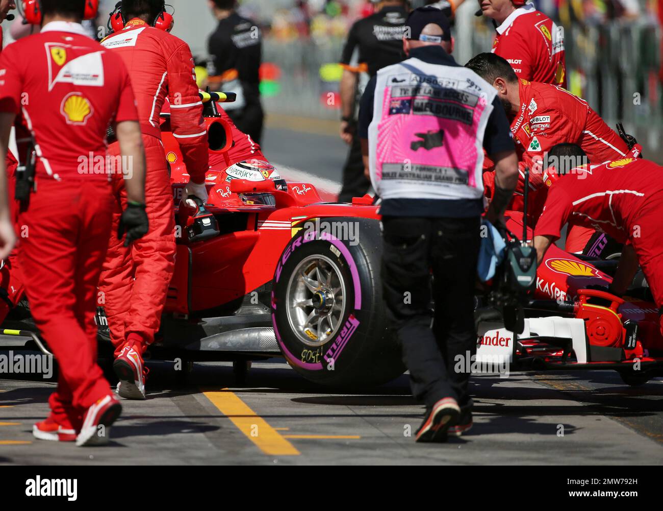 Mechanics push Ferrari driver Kimi Raikkonen of Finland's car back into ...