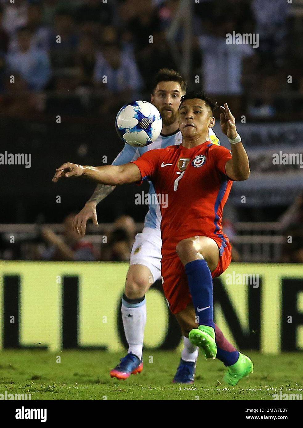Chile’s Alexis Sanchez controls the ball as Argentina’s Lionel Messi ...