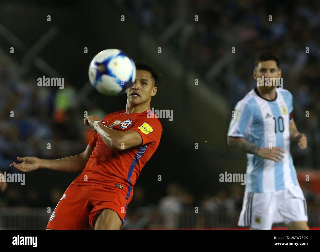 Chile’s Alexis Sanchez eyes the ball as Argentina’s Lionel Messi looks ...