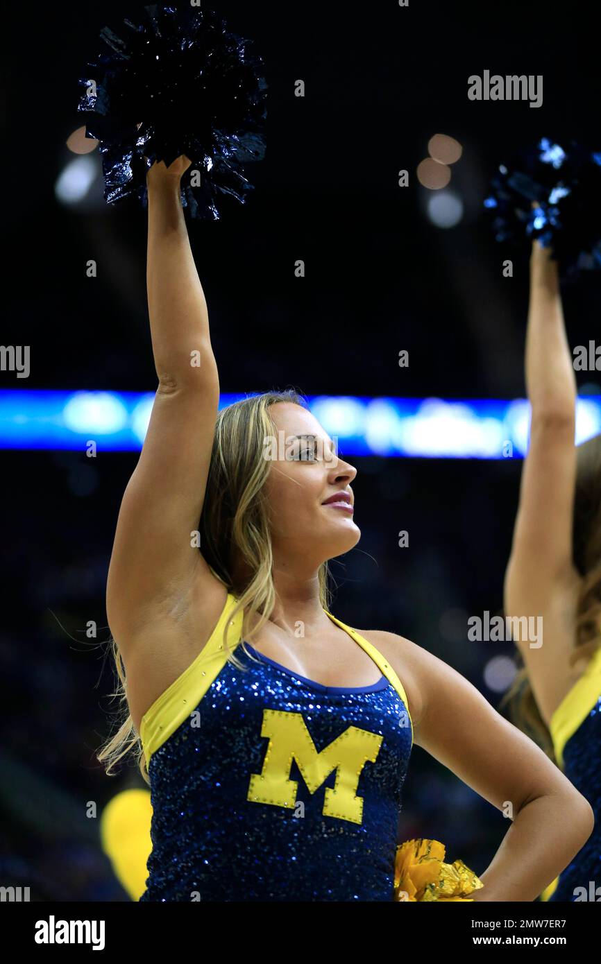 A Michigan cheerleader performs before an NCAA college basketball game ...