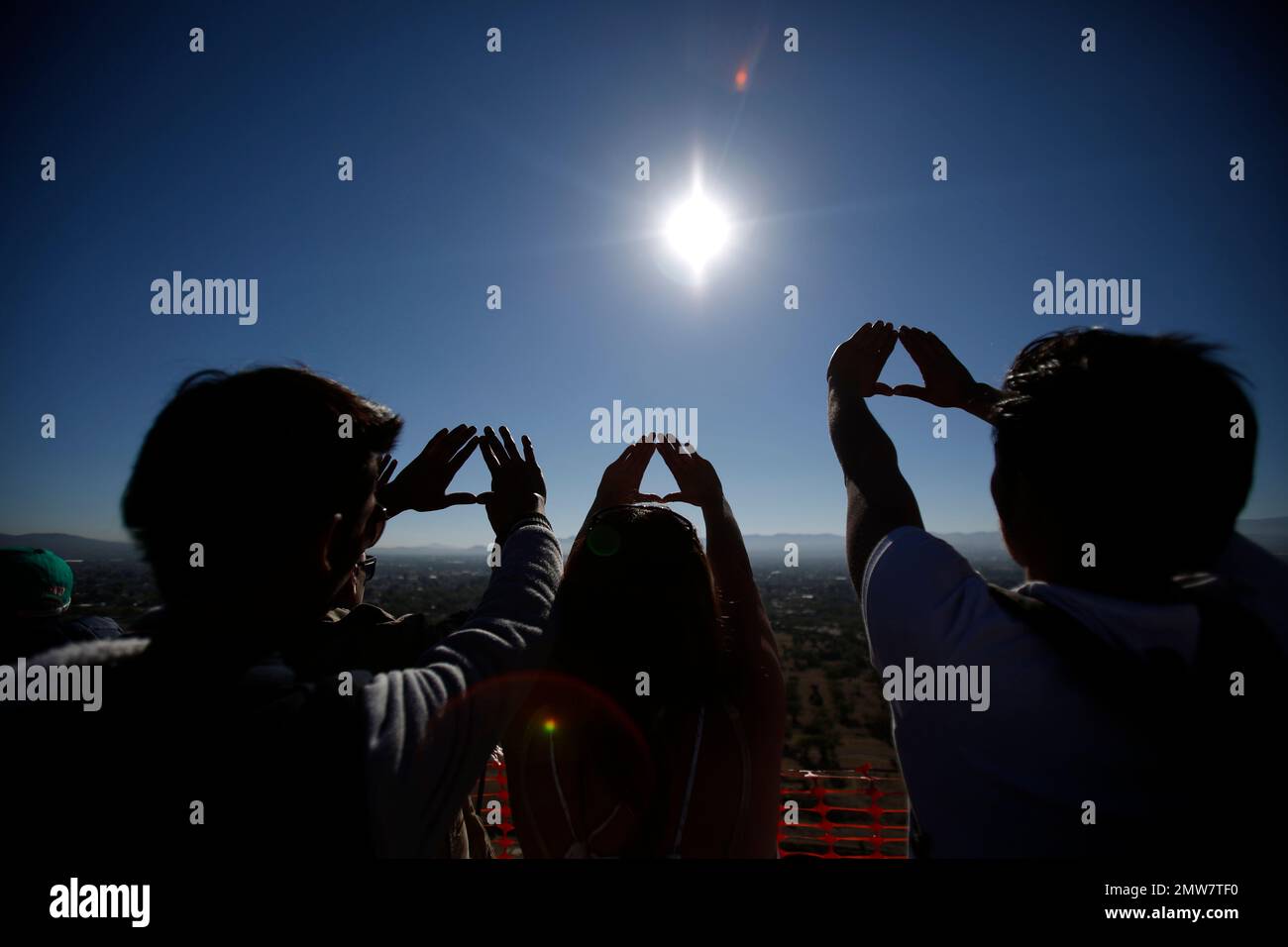 Visitors celebrating the spring equinox raise their hands in the shape ...