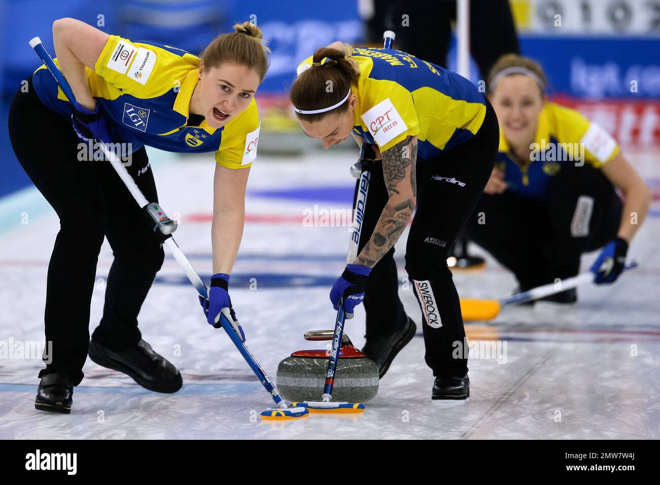 Sweden's Sara McManus, left, shouts as she sweeps the path for the ...