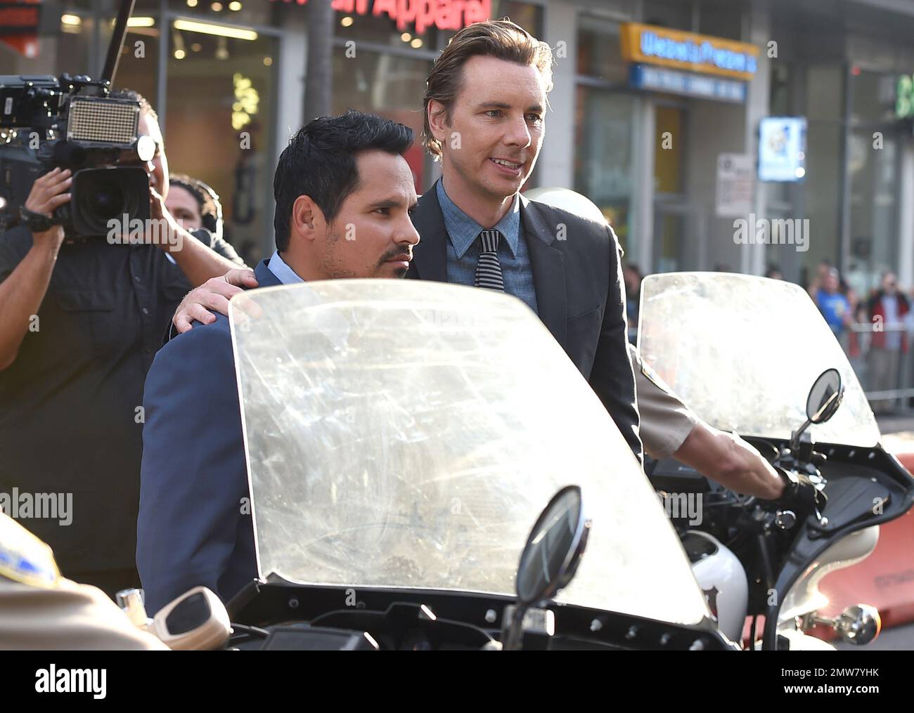 Actors dressed as police officers escort Dax Shepard, standing right ...