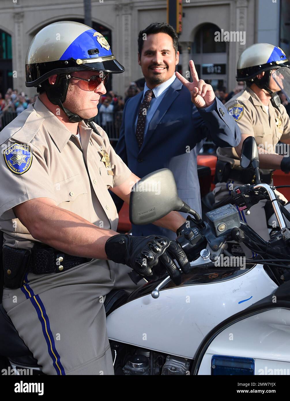 Actors dressed as police officers escort Michael Pena, center, as he ...